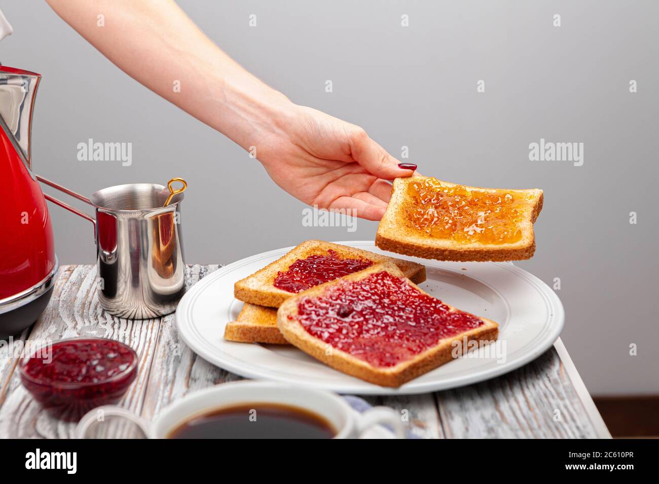 Female hands preparing toasts with fruit jam Stock Photo - Alamy