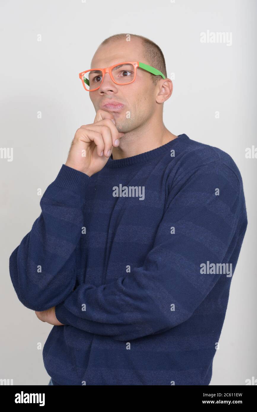 Portrait of young bald nerd man thinking Stock Photo - Alamy