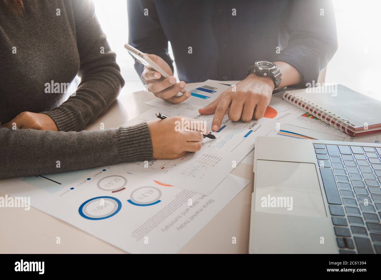 Two business people working together on stock market strategy ...
