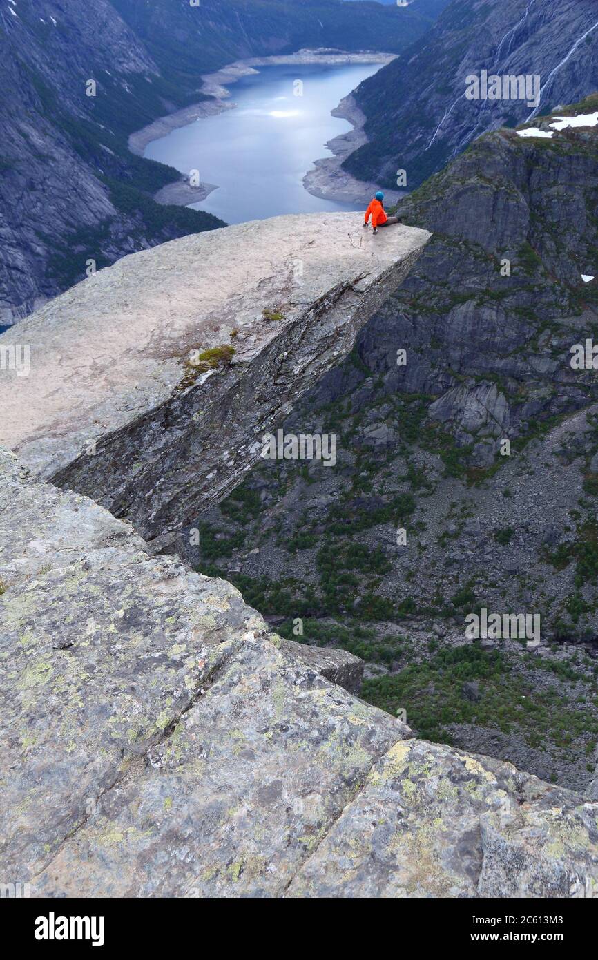 Sitting on the edge of Troll's Tongue in Norway. Tourist attraction ...