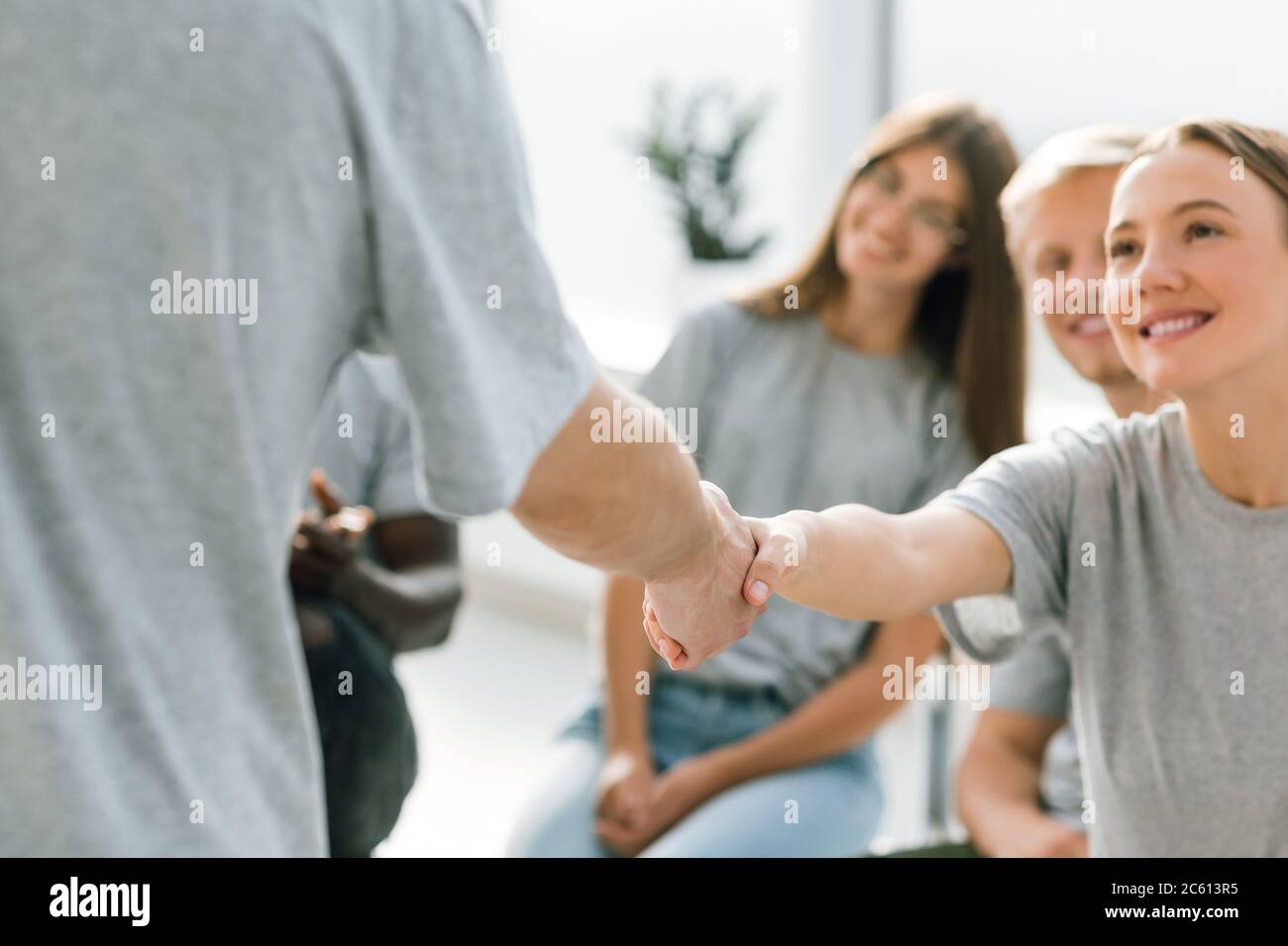 young employees greeting each other with a handshake Stock Photo - Alamy