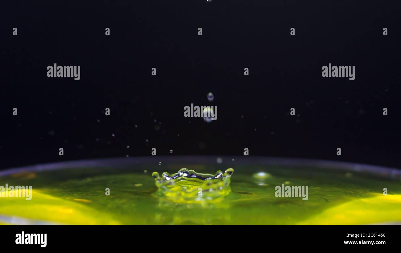 Yellow color water drop falling in water, freezing the moment Stock ...