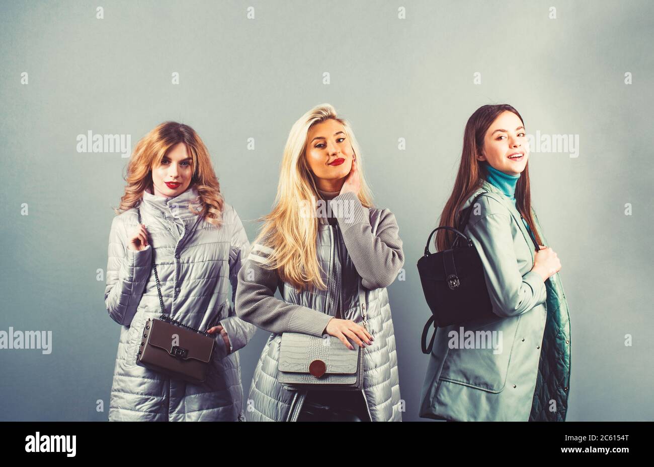 Studio portrait of a group of three young beautiful model smiling and ...