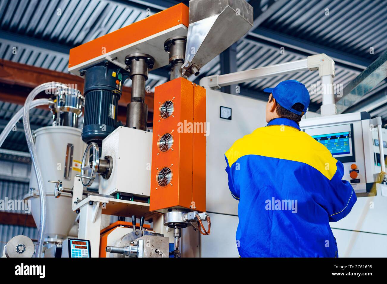 Man worker in manufacturing plant at cable factory machine control ...