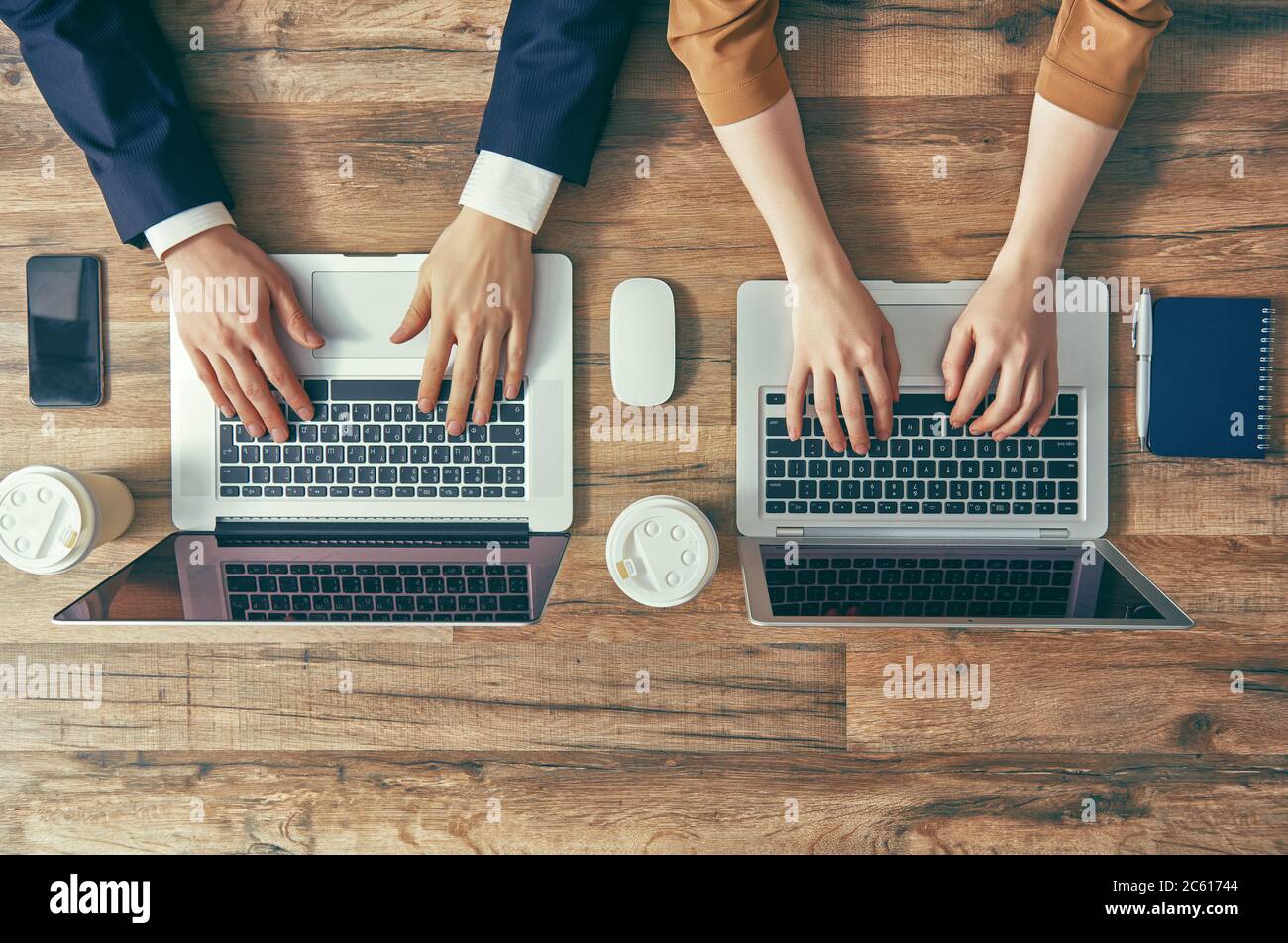 man and woman working on their computers. the view from the top. two ...