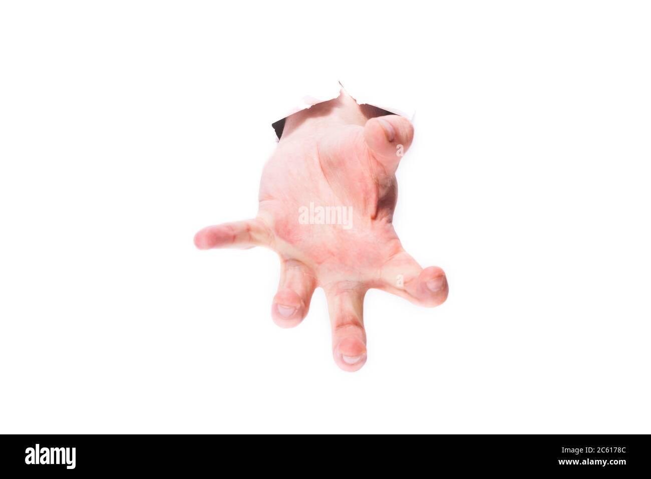male hand thrust through a hole in paper on a white background isolate ...