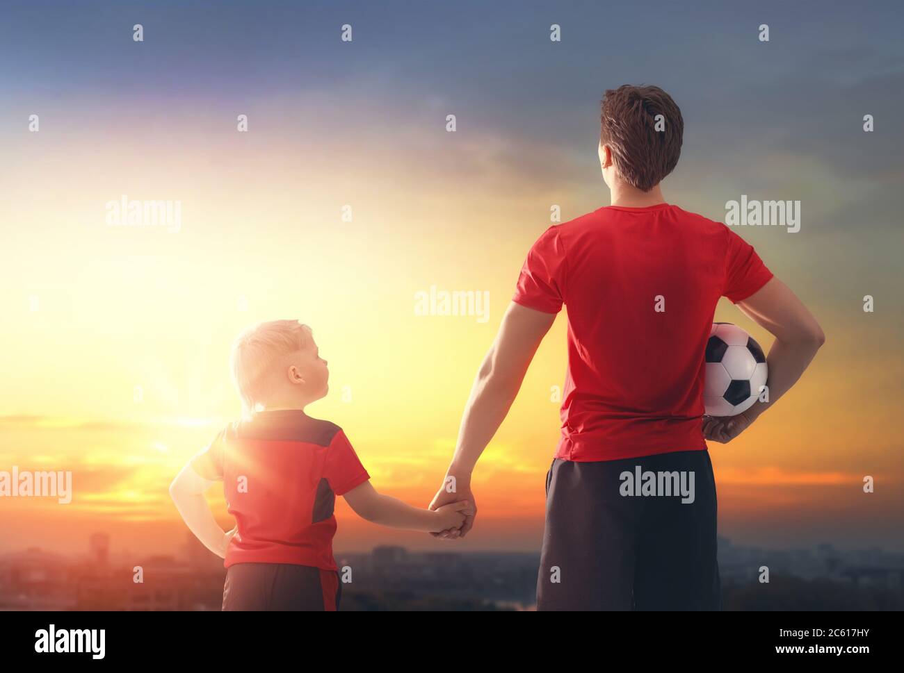 Cute little child dreaming of becoming a soccer player. Boy with man ...