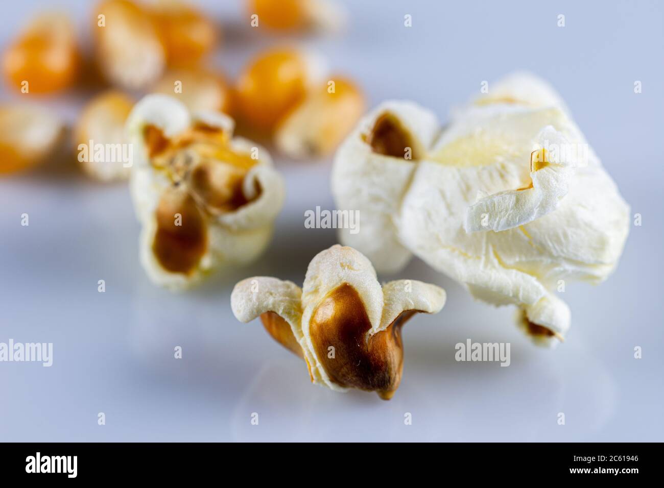 Popcorn popped up with some corn kernels on a light background Stock ...