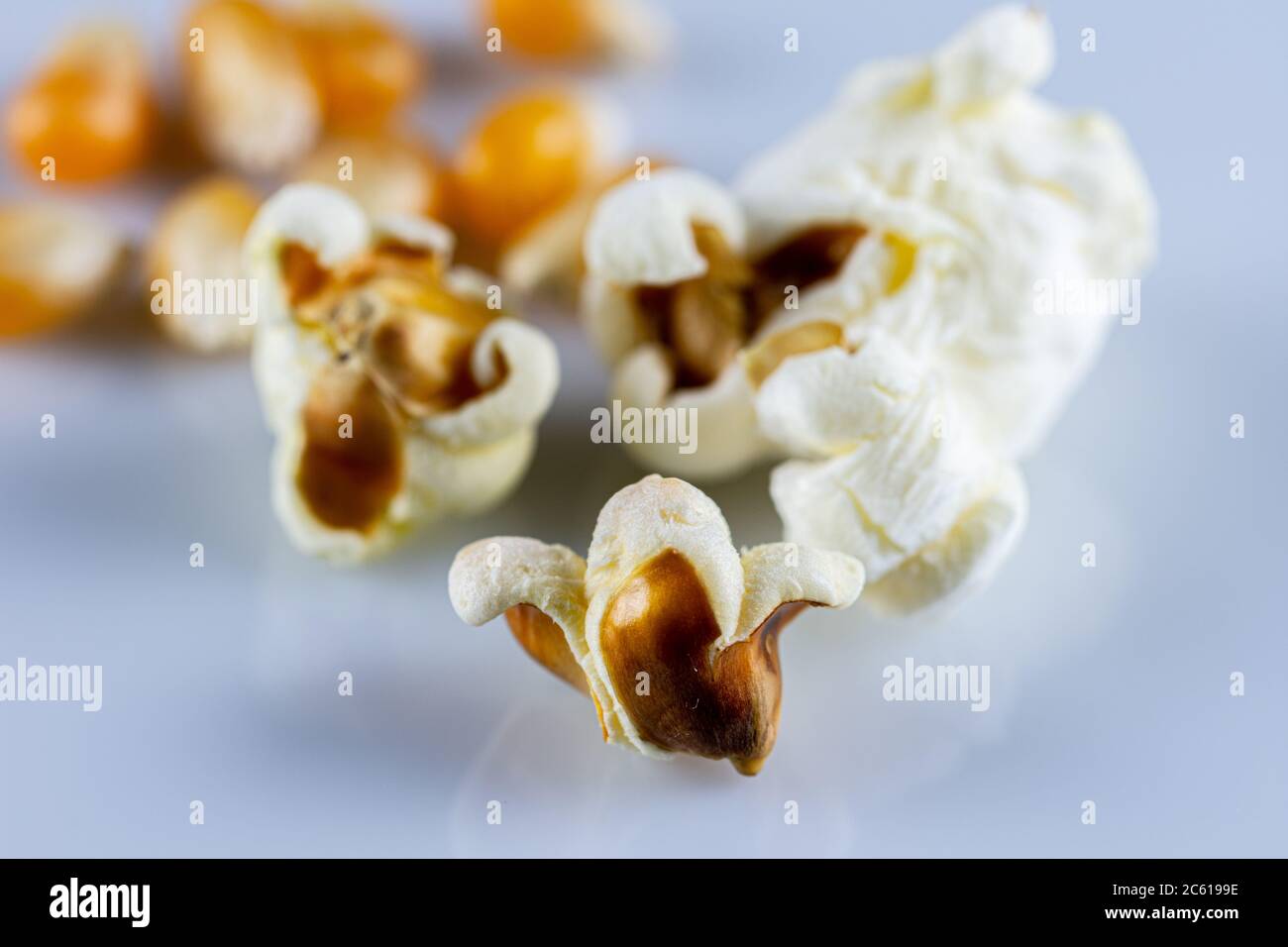 Popcorn popped up with some corn kernels on a light background Stock ...