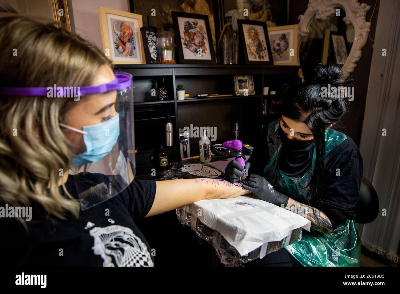 Tattoo artist Kristy Mick (right) tattooing customer Chloe McEnhill at ...