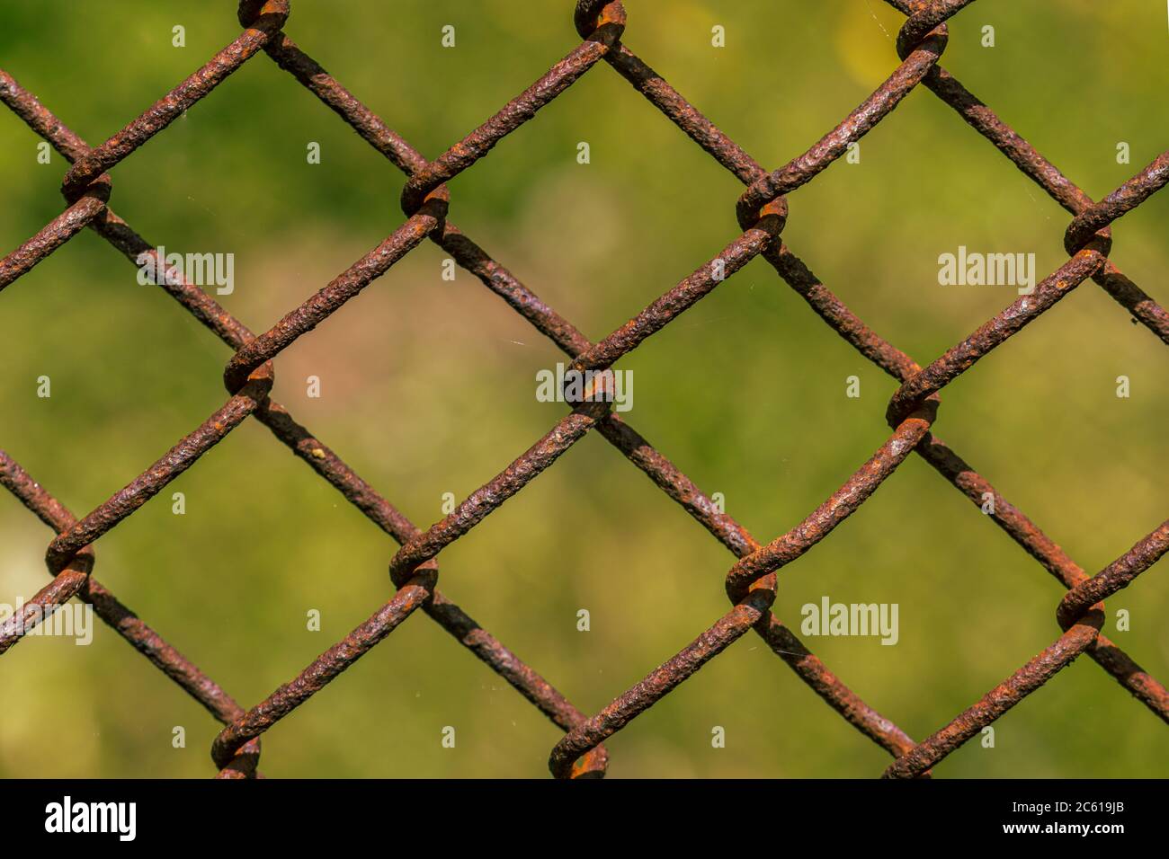 Rusted old metal fence weave close up, grass background Stock Photo - Alamy