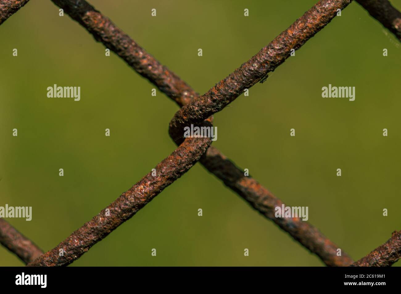 Rusted old metal fence weave close up, grass background Stock Photo - Alamy