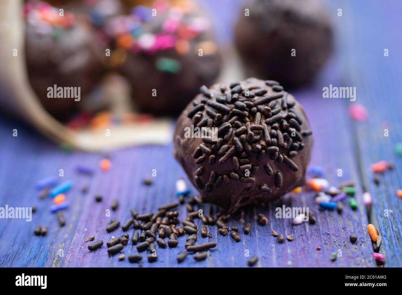 Chocolate donut holes with sprinkles in paper cone, copy space Stock ...