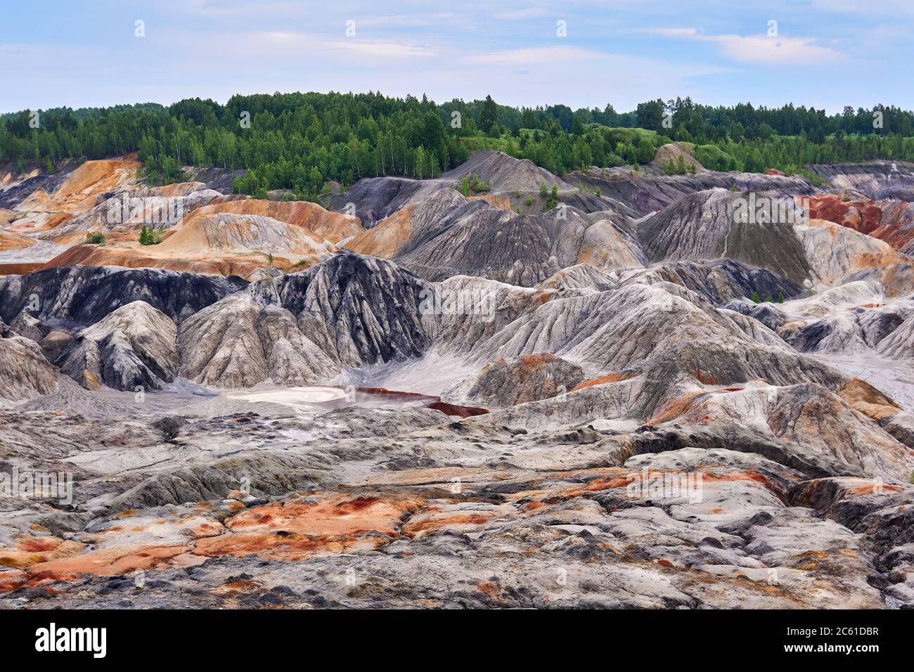 multi-colored eroded hills and destroyed soil layer at the open cast ...