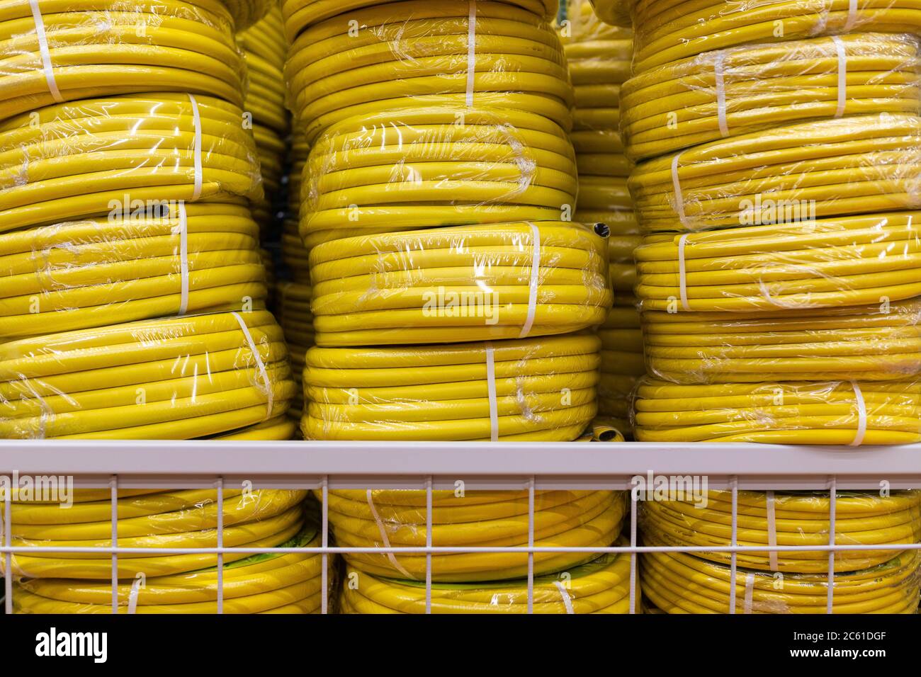 warehouse of a construction store with twisted hoses for watering the ...