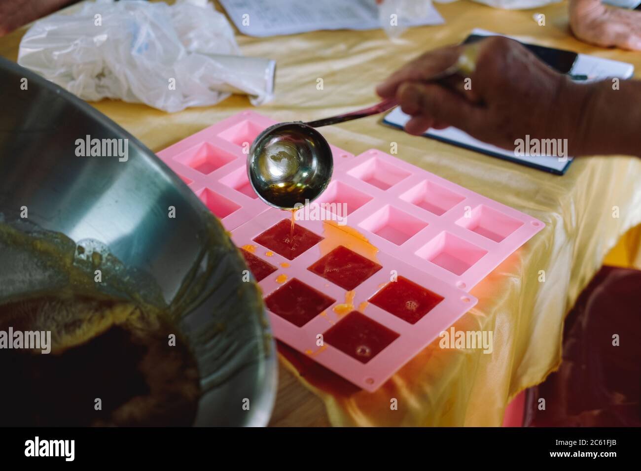 hand pouring homemade soap mixture on plastic form Stock Photo - Alamy