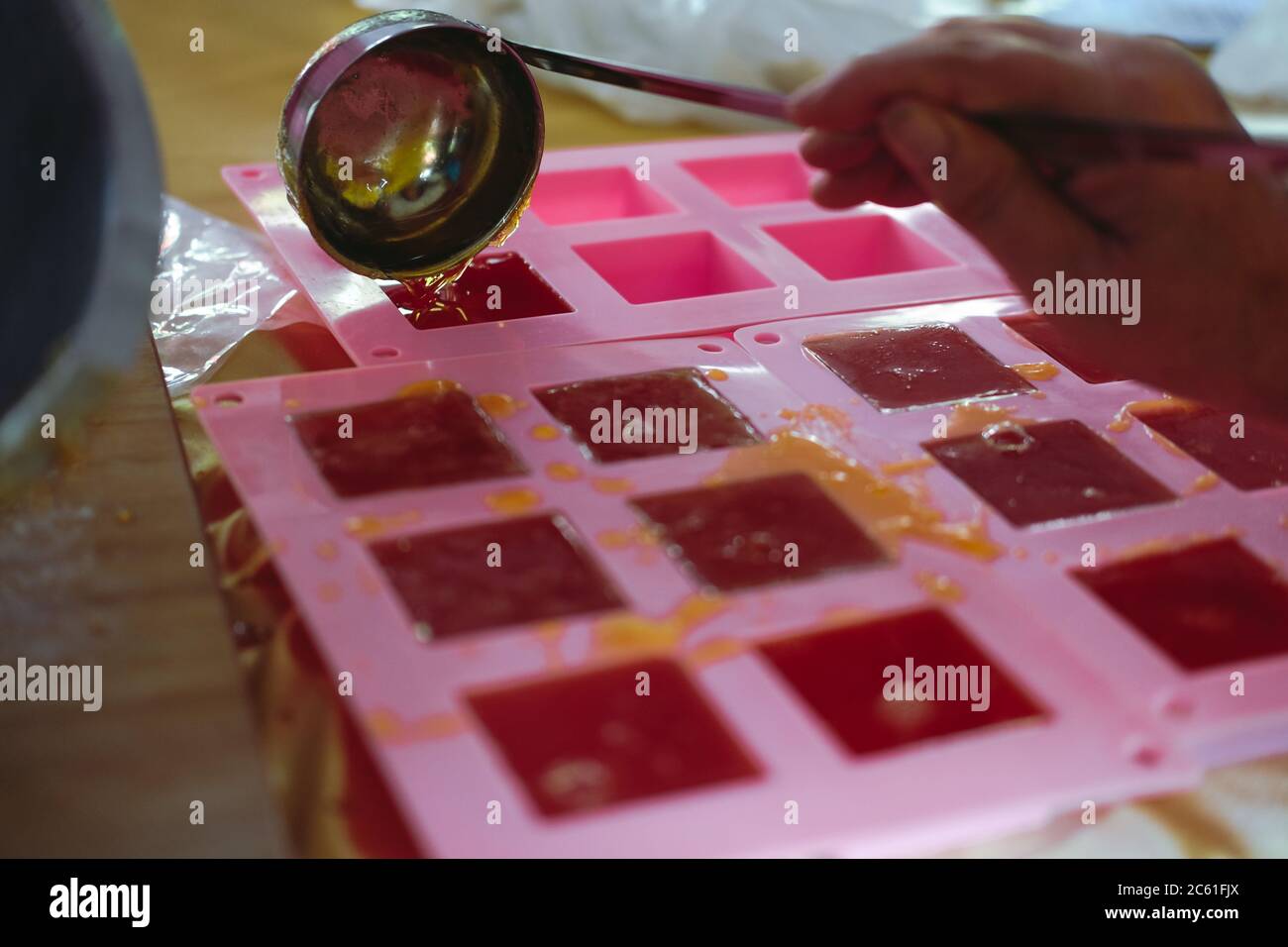 hand pouring homemade soap mixture on plastic form Stock Photo - Alamy