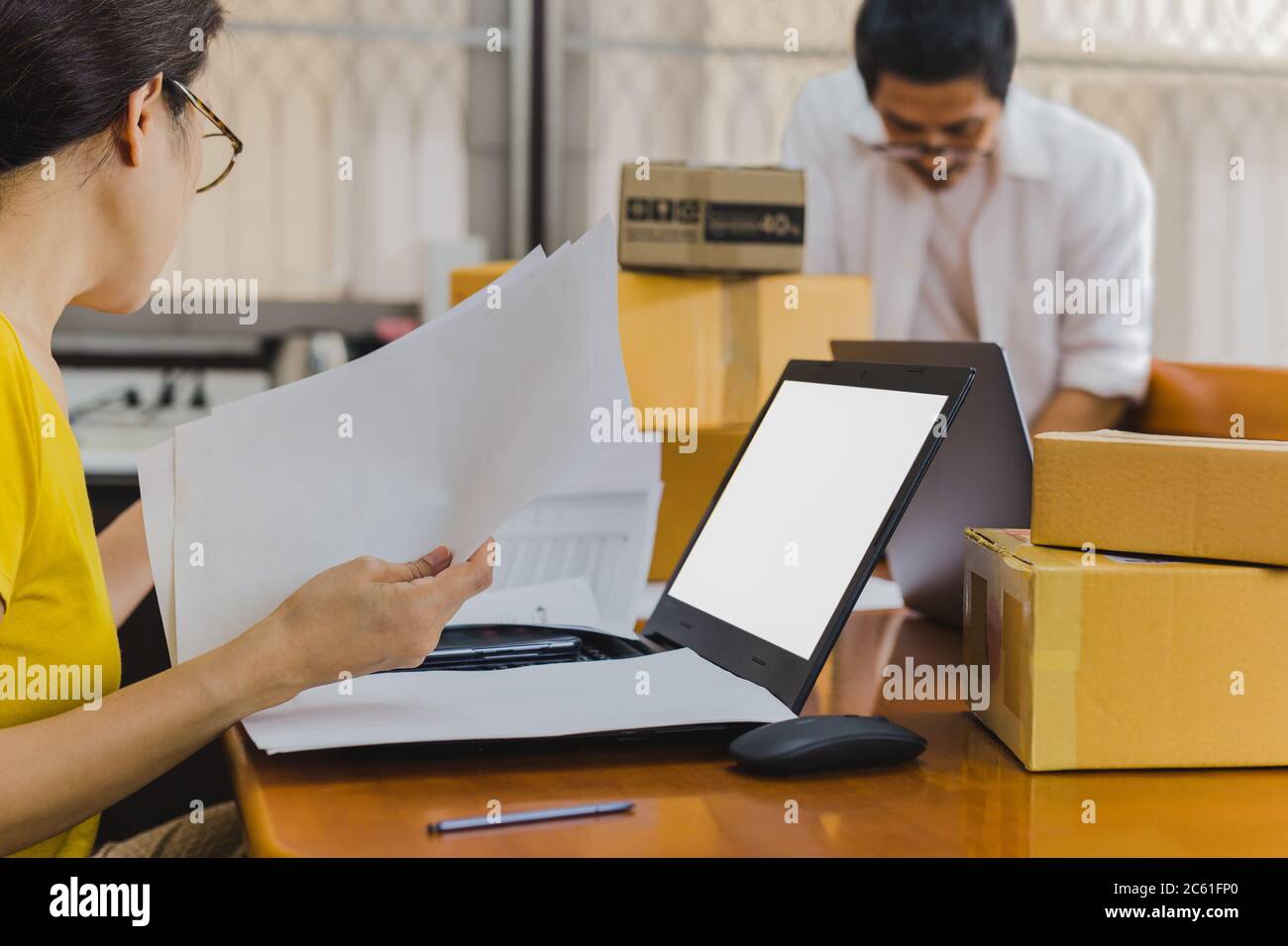 Couple checking document with open laptop and parcels on table Stock ...