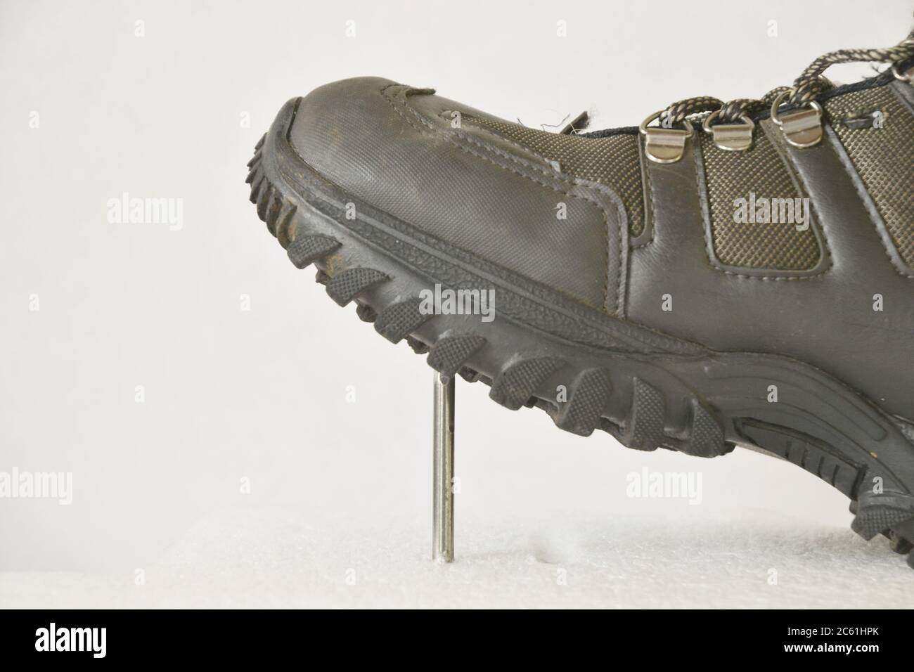 Worker in safety boots, leather stepping on a nail, leather boot in ...