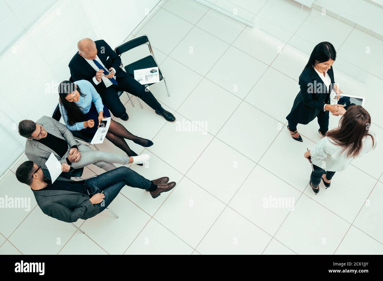 top view. a group of employees using their devices in the workplace ...