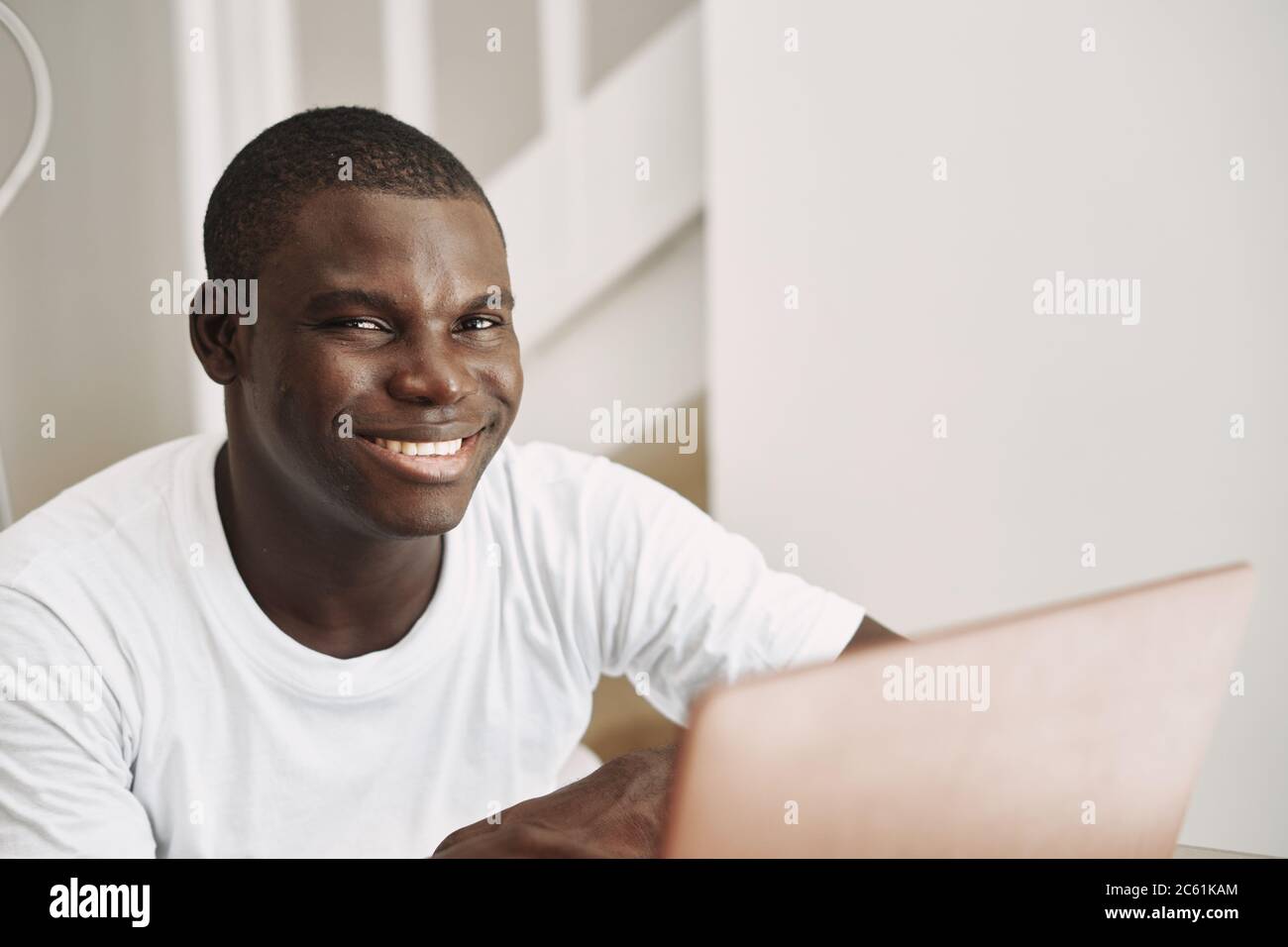 A happy guy of African appearance smiles and laptop Stock Photo - Alamy