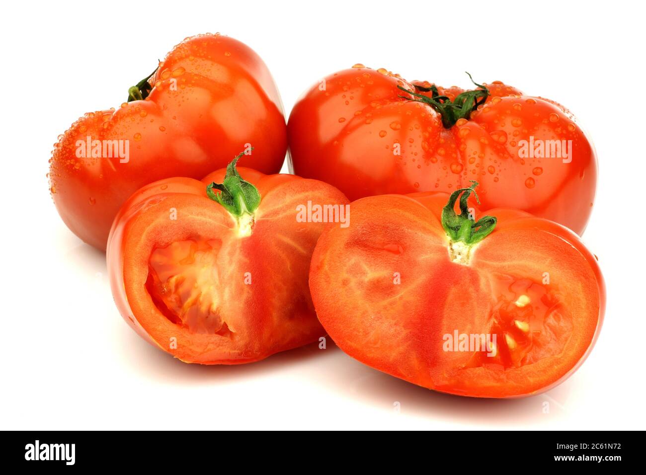 fresh beef tomatoes and a cut one on a white background Stock Photo - Alamy