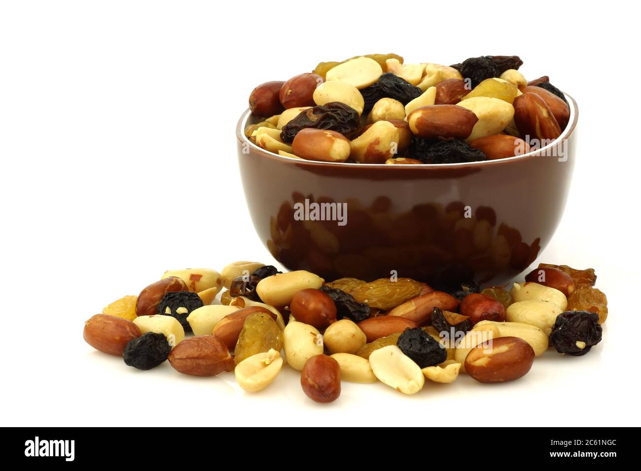 mixed peanuts and raisins in a brown bowl on a white background Stock ...