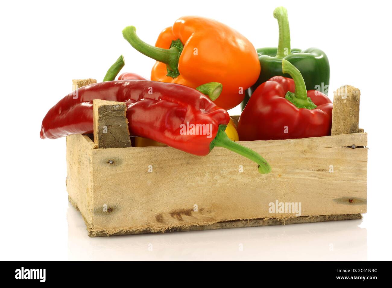 colorful mix of paprika's(capsicum) in a wooden box on a white ...