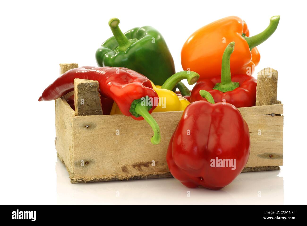 colorful mix of paprika's(capsicum) in a wooden box on a white ...