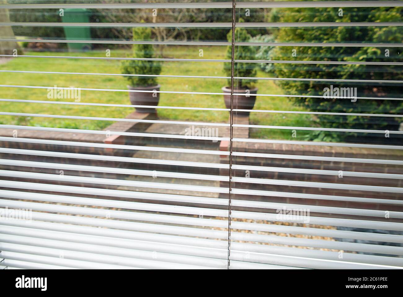 image of garden through Venetian blinds looking like bars across the ...