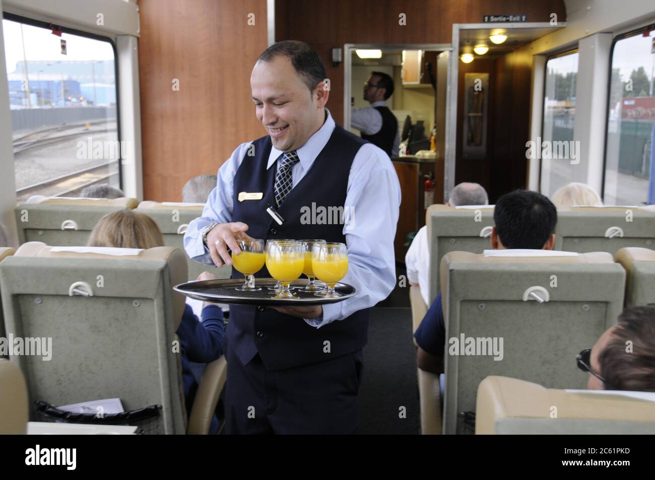 A restaurant-car attendant serving Welcome drinks to passengers on ...