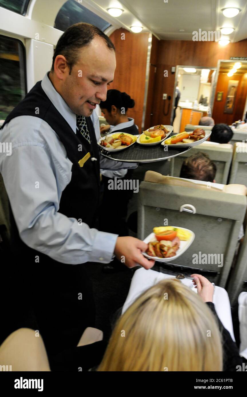A restaurant-car attendant serving a cooked breakfast on board the ...