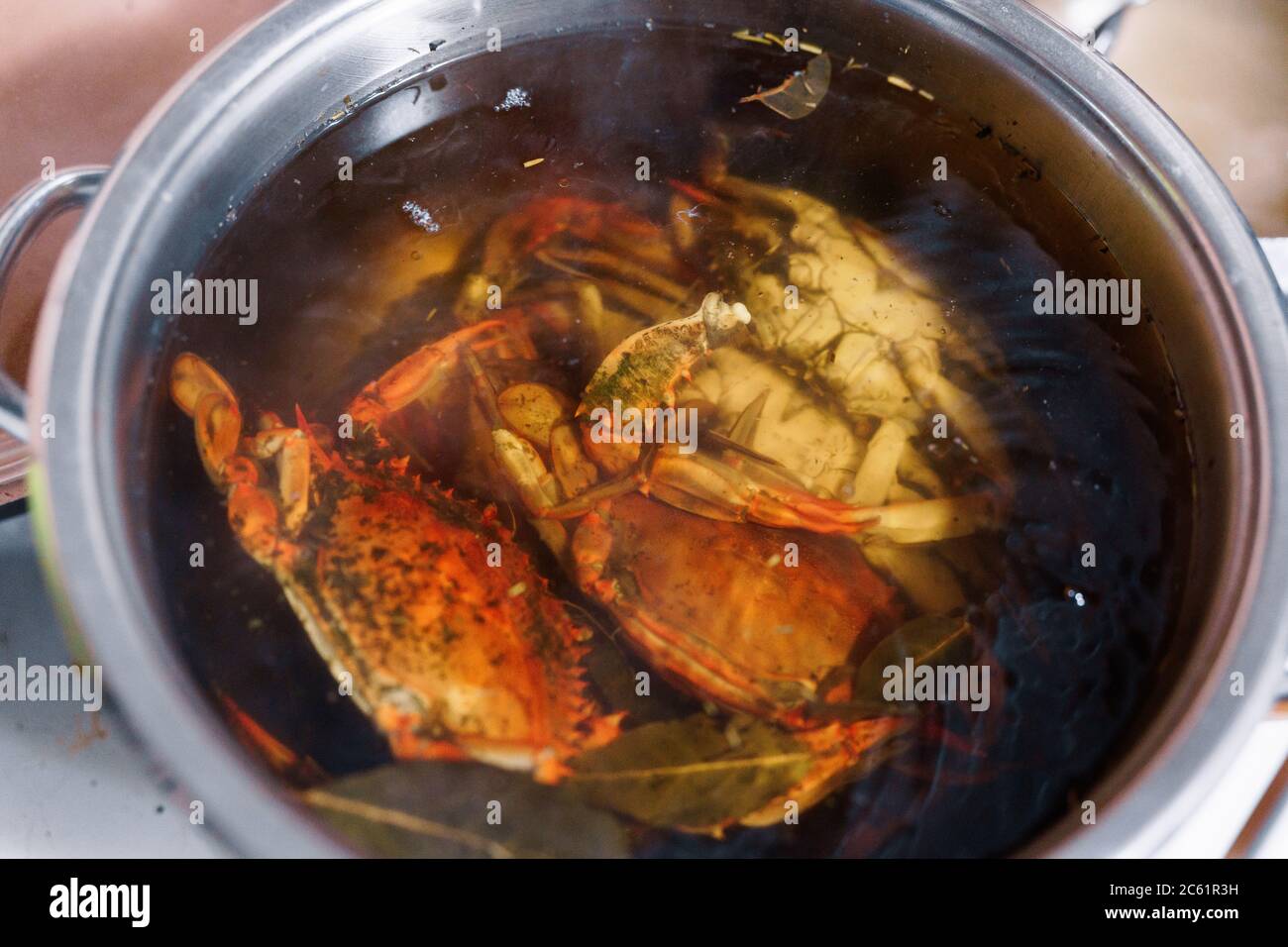 Red boiled blue crabs in boiling water with seasonings Stock Photo - Alamy