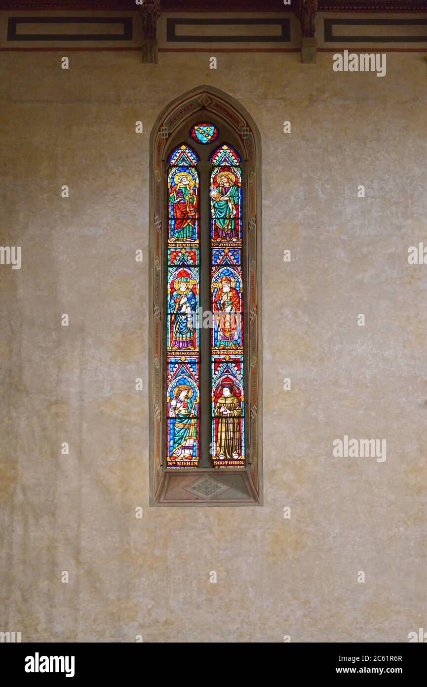 Masterpiece of medieval art. Stained-glass window on the stone wall of ...