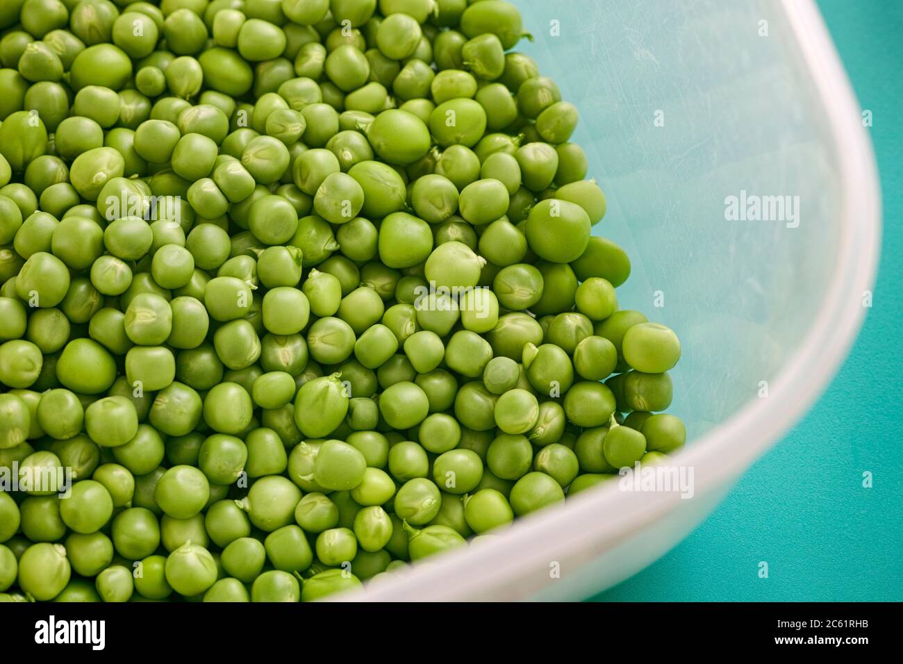 Green peas in a plastic container. Close up Stock Photo - Alamy
