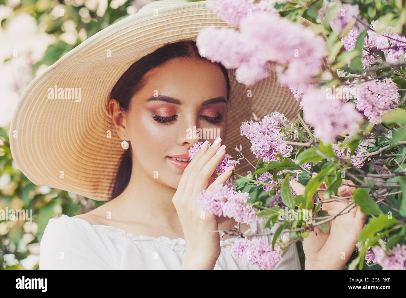 Beautiful woman smelling flowers outdoors Stock Photo - Alamy