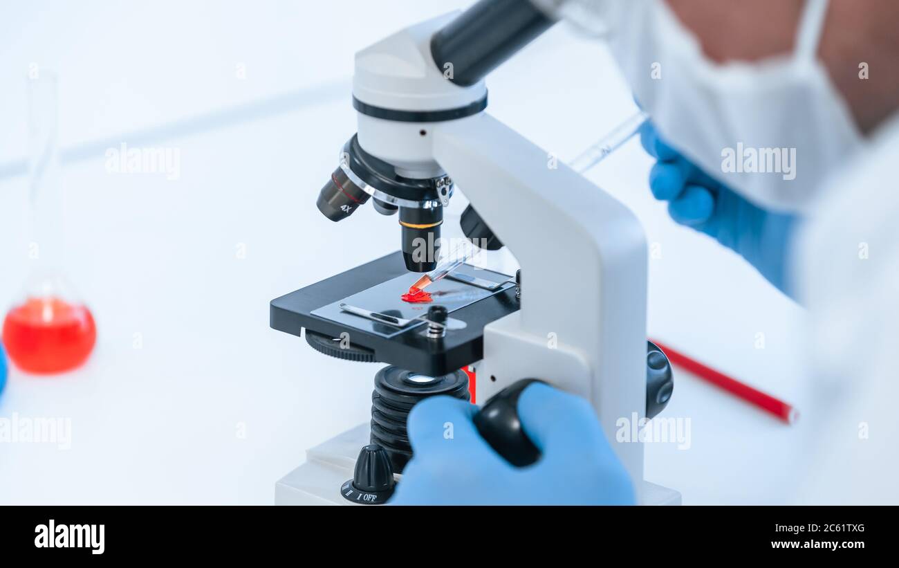 close up. scientist using a microscope to study blood Stock Photo - Alamy