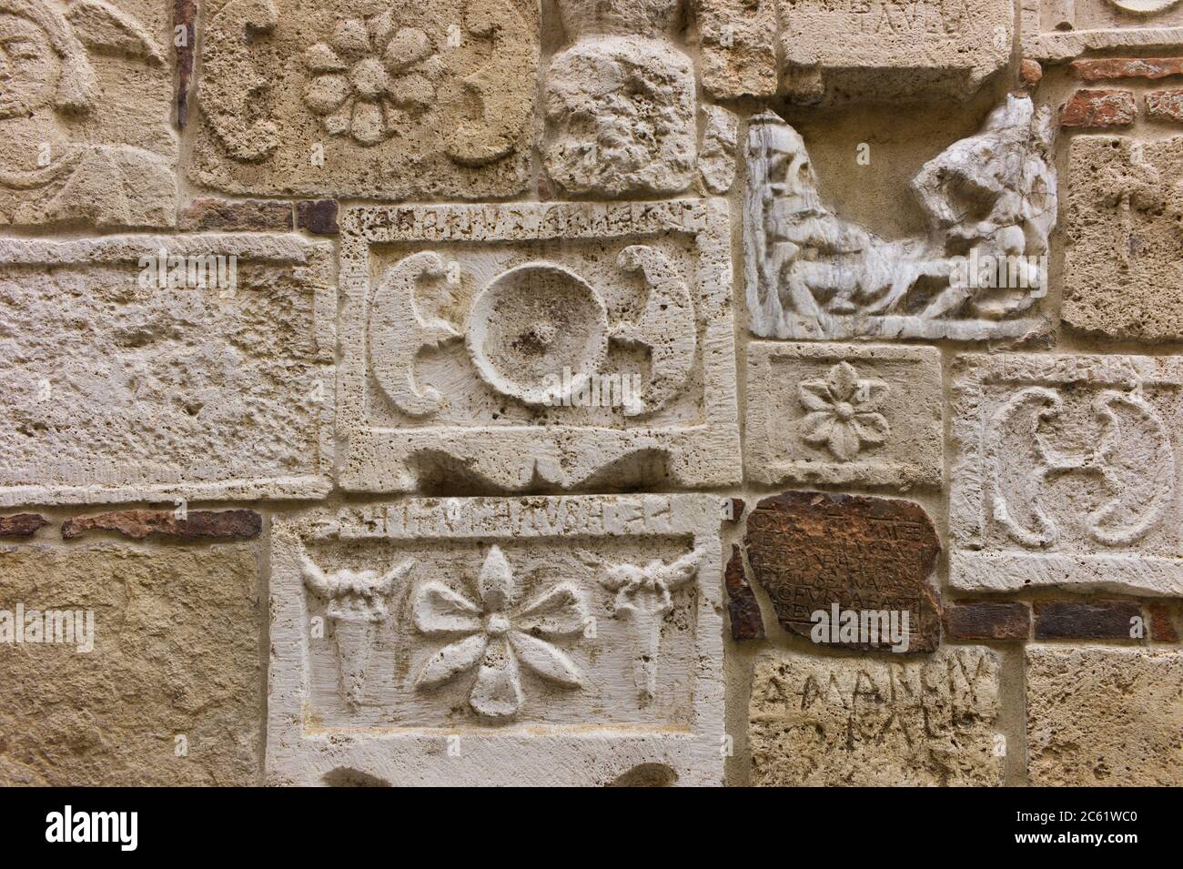 Etruscan and Roman stone carving reliefs on a wall of Palazzo Bucelli ...