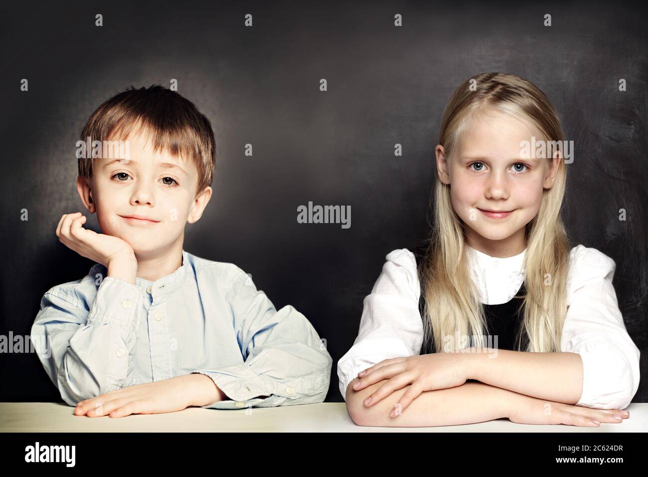 Smart school children girl and boy on blackboard background Stock Photo ...