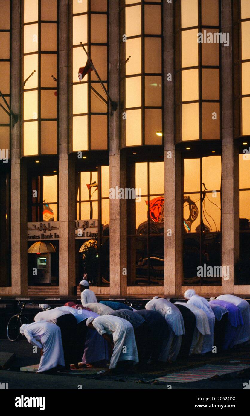 Dubai UAE Men at Friday Prayer at Sunset outside Emirates Bank Stock ...