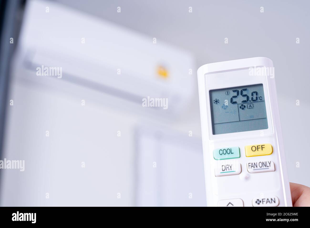 Human hand is using white remote of air conditioner for turn on or ...