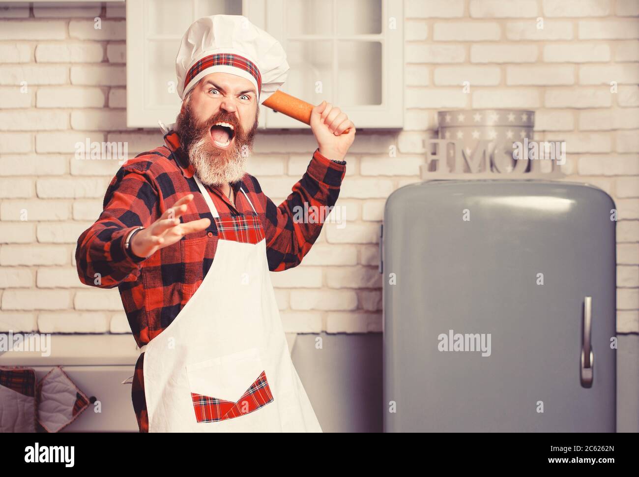 Cooking food concept. Holding rolling pin, clenching fist, screaming ...