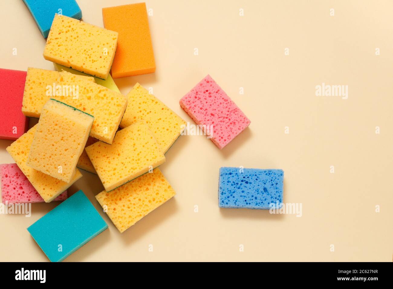 Sponges of different colors on a beige background. Top view. Washing ...