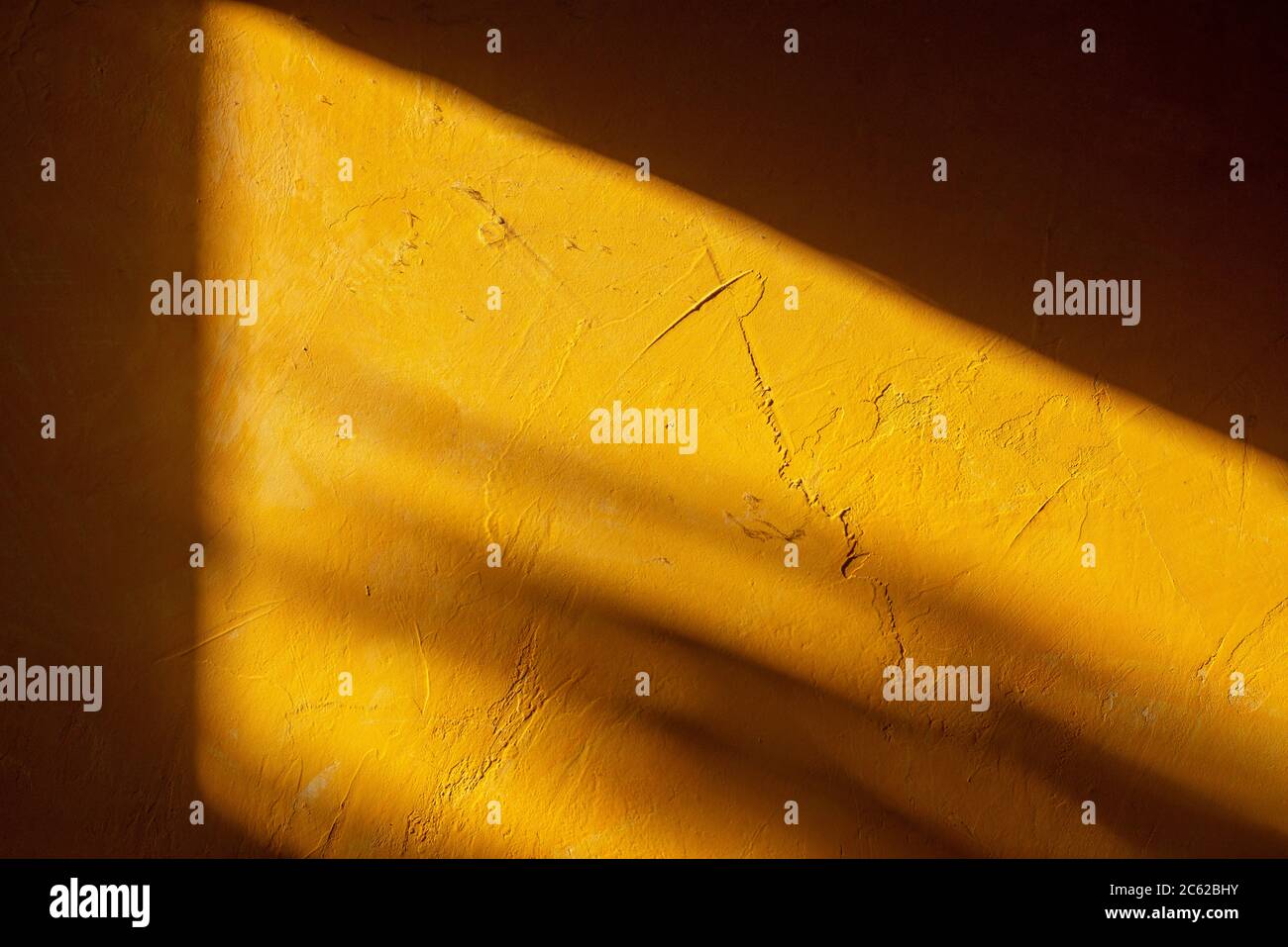 sunlight stripe and scenic shadows on yellow stucco wall Stock Photo ...