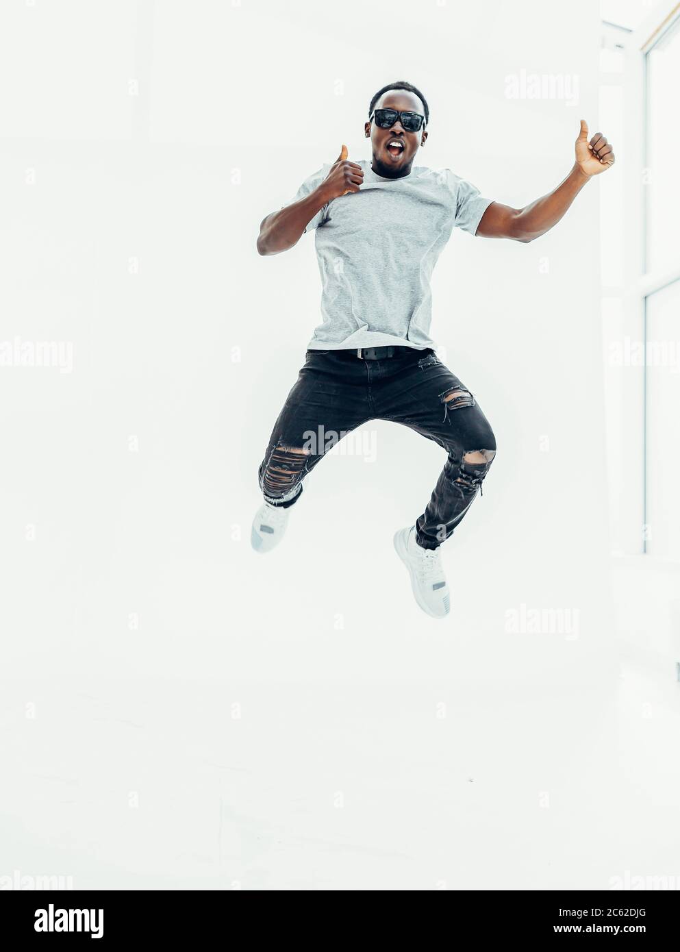 in full growth. happy dancing guy showing thumbs up Stock Photo - Alamy