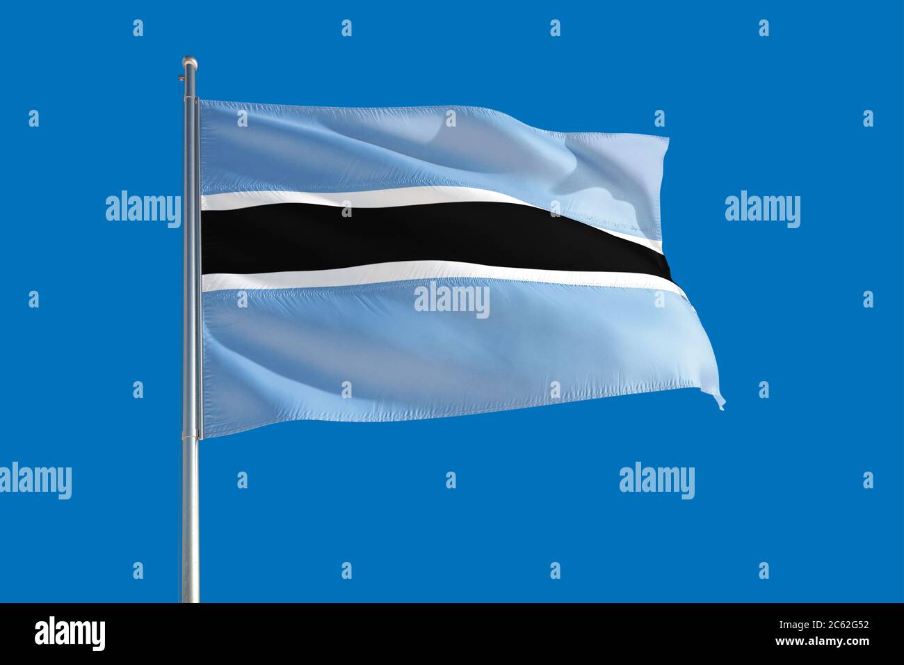 Botswana national flag waving in the wind on a deep blue sky. High quality fabric. International ...