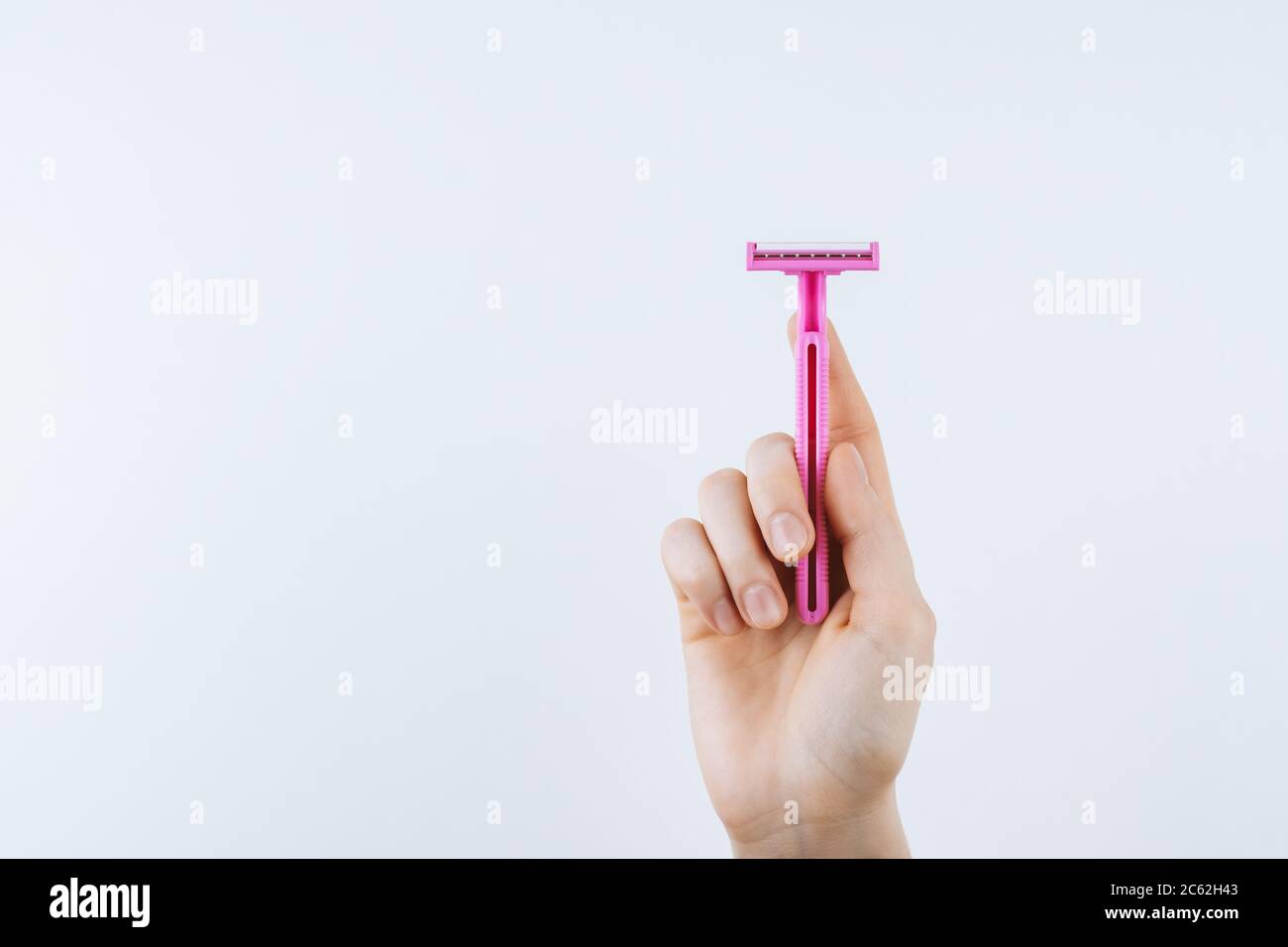 Female hand takes pink disposable razor Stock Photo - Alamy