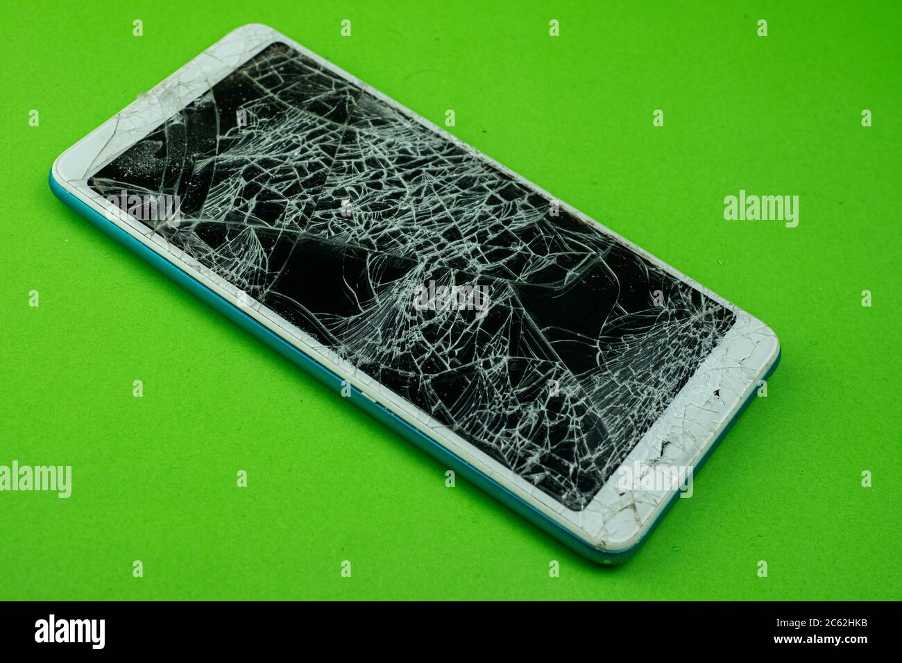 Smartphone screen is cracked on green background Stock Photo - Alamy