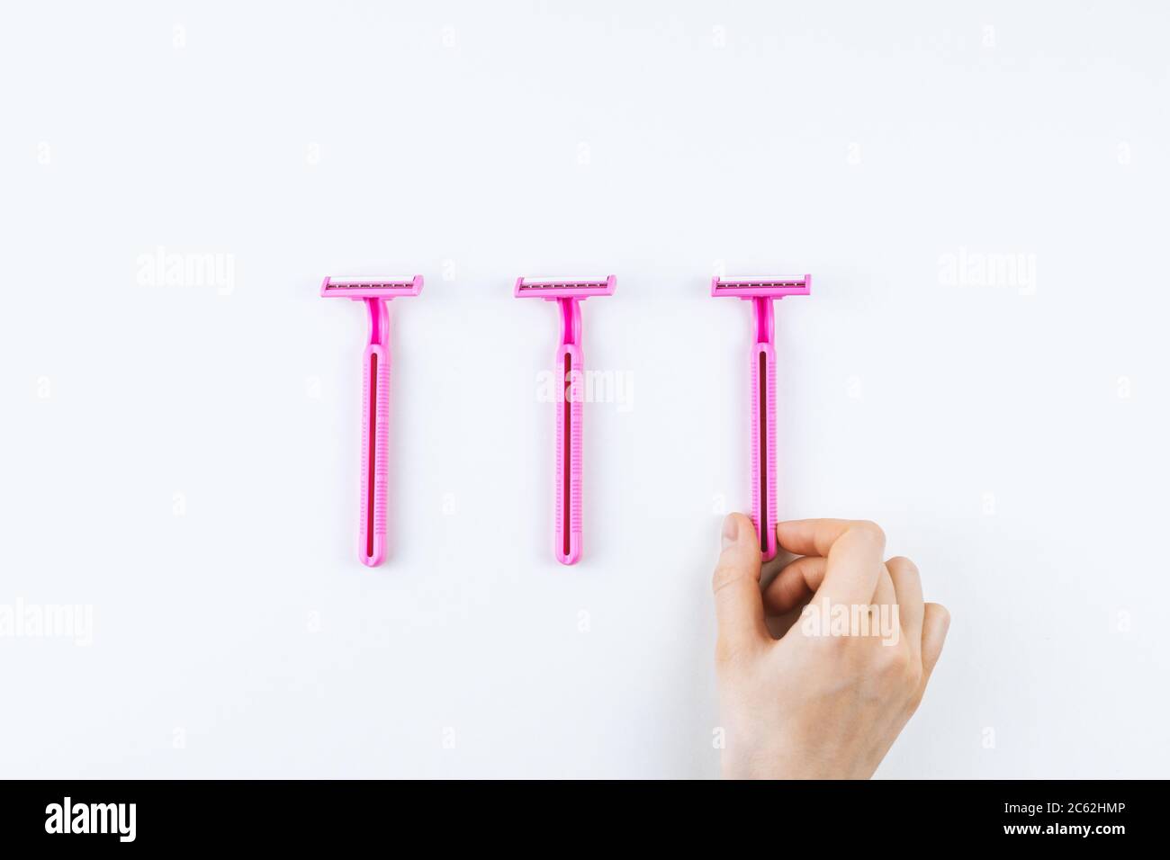 Female hand takes pink disposable razor Stock Photo - Alamy