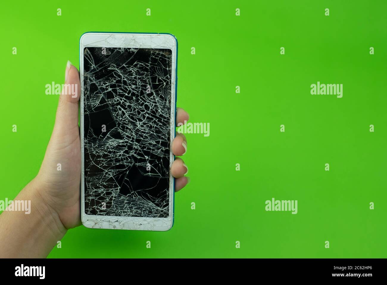 Hand holding smartphone screen is cracked on green background Stock ...